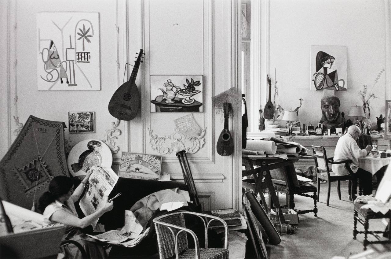 Picasso painting plates at the dining table, with Jacqueline reading ...
